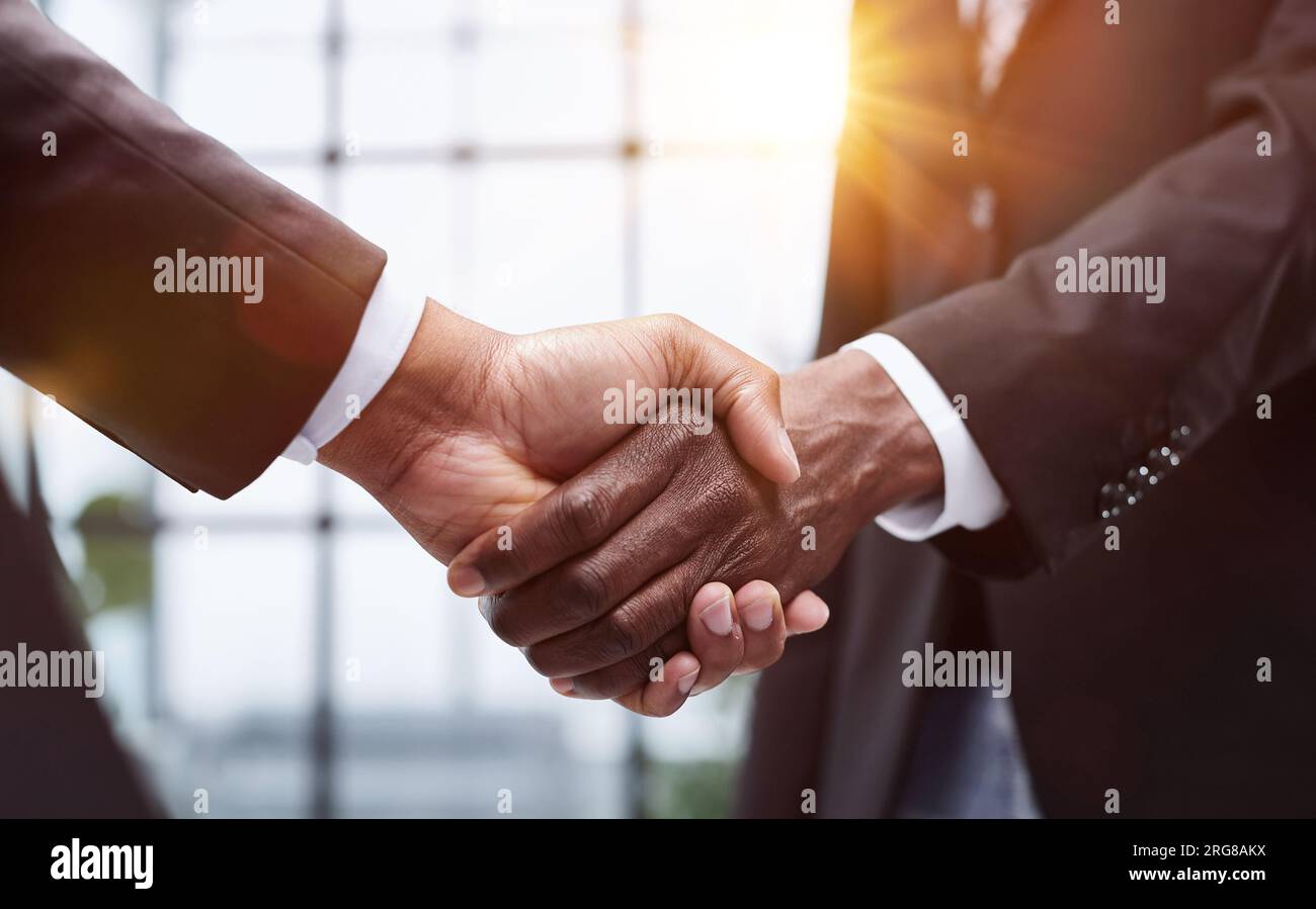 Businessmen reach out to each other to shake hands Stock Photo - Alamy