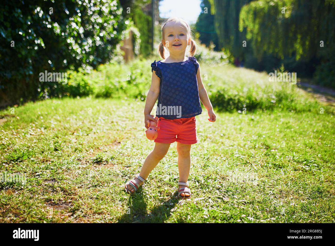 Adorable toddler girl walking in park or forest. Child having fun ...