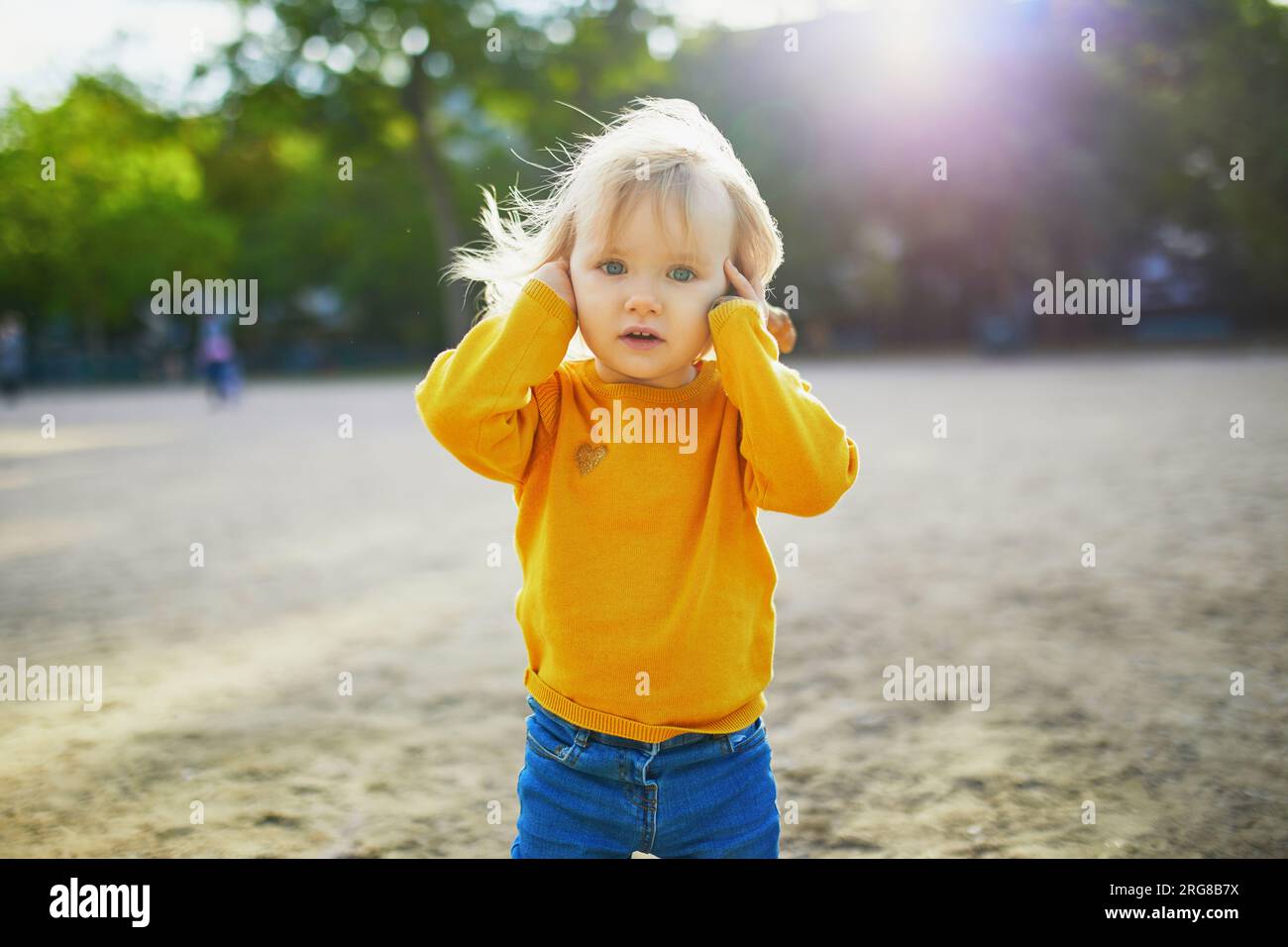 Adorable toddler girl walking in park on a sunny evening. Child having ...