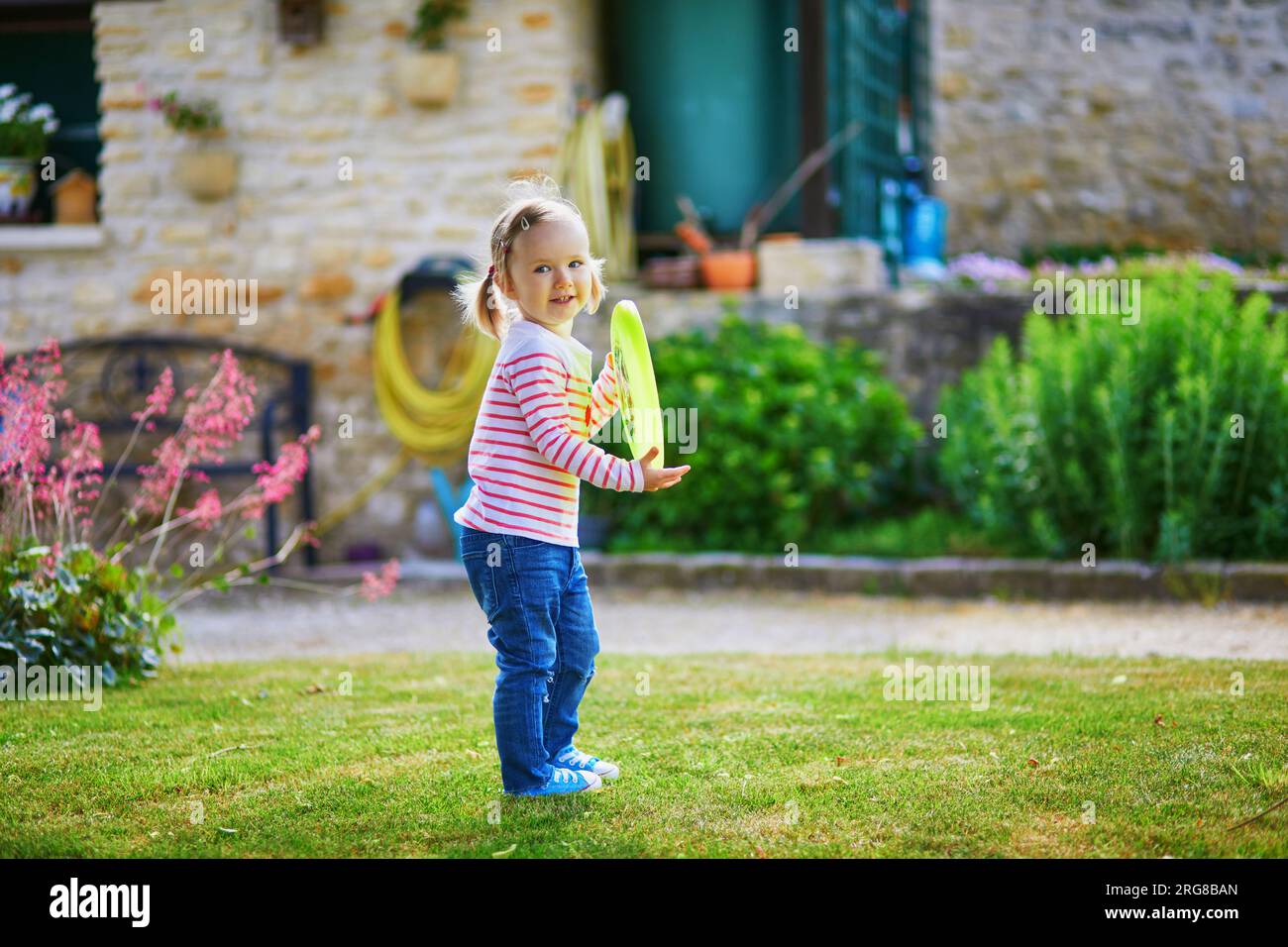 Adorable toddler girl playing frisbee. Child having fun outdoors on a ...
