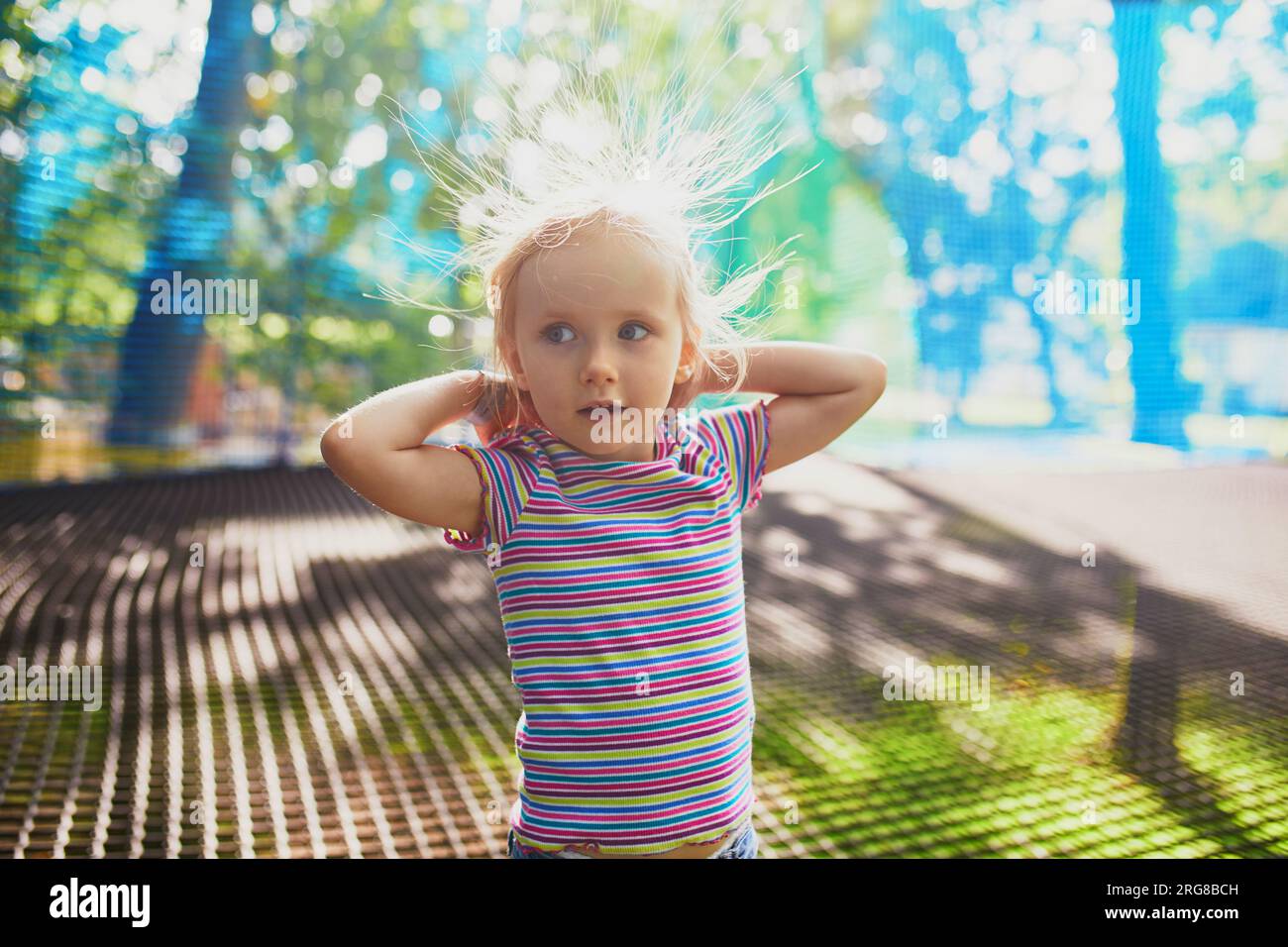 Adorable little girl having fun in adventure park. Child with ...