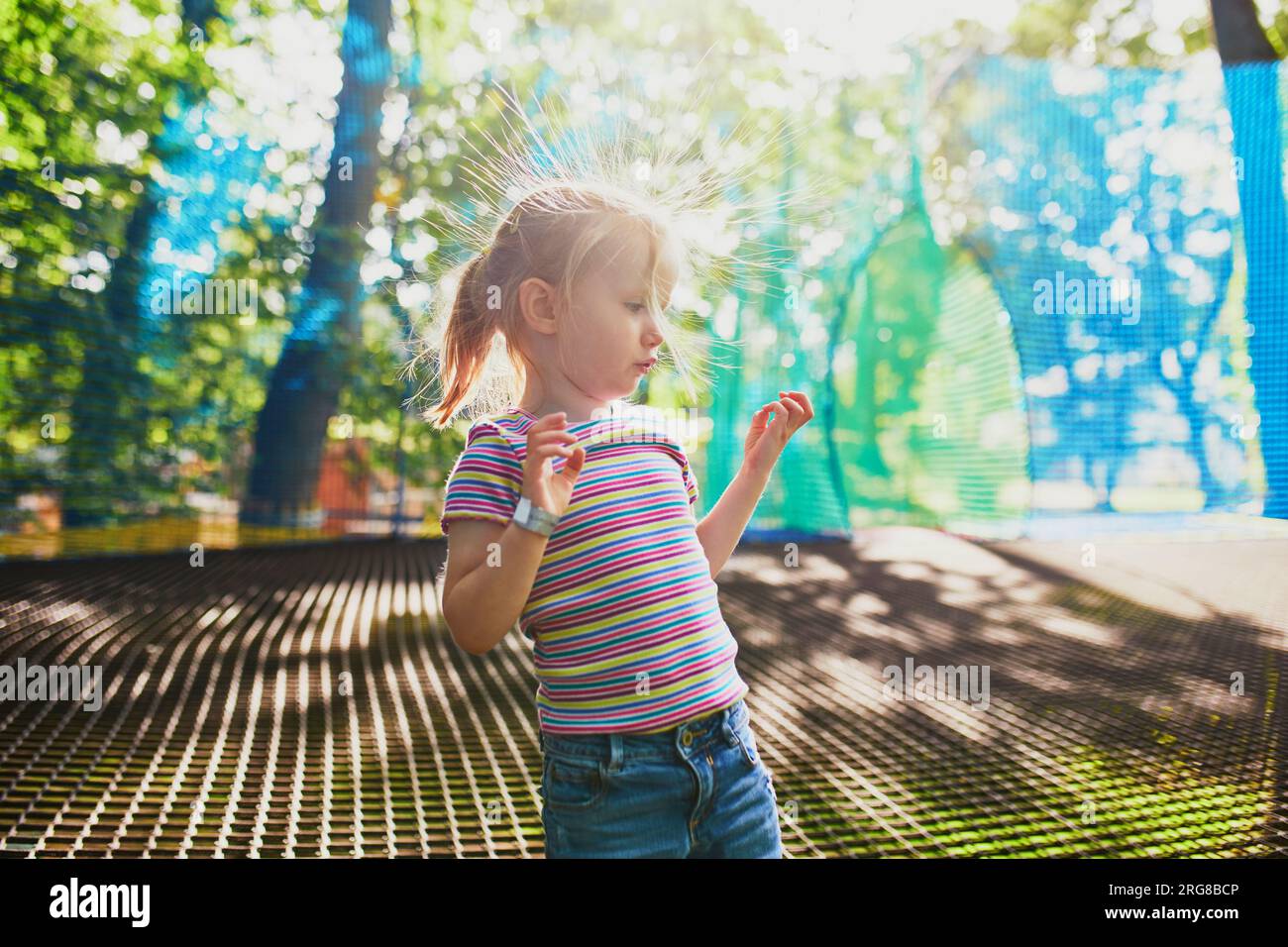 Adorable little girl having fun in adventure park. Child with ...