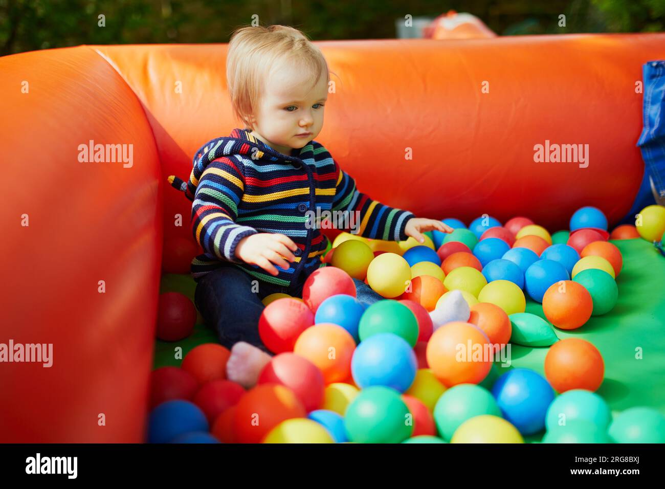 Little girl playing in ball pool. Toddler having fun with balls ...