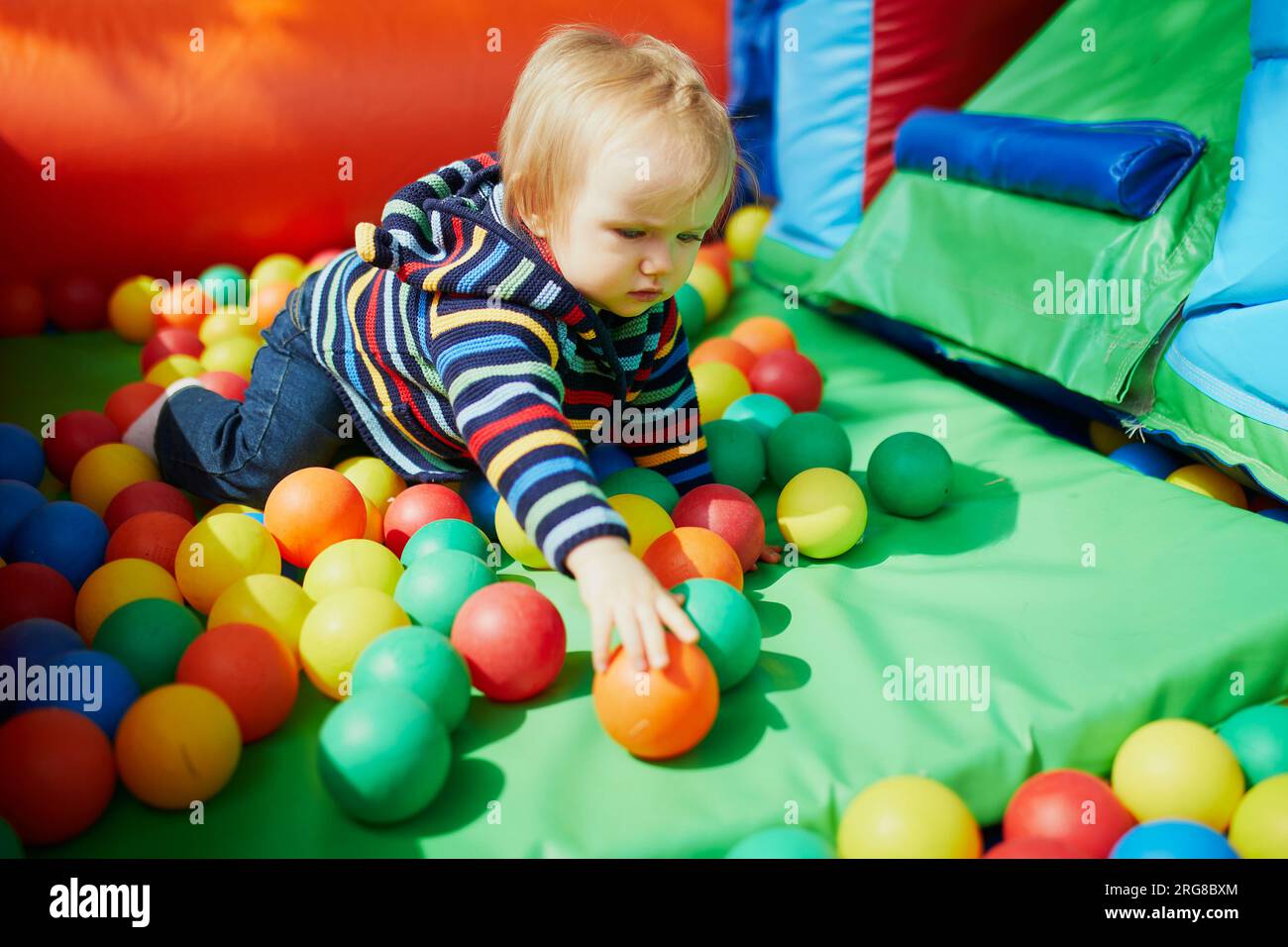 Little girl playing in ball pool. Toddler having fun with balls ...