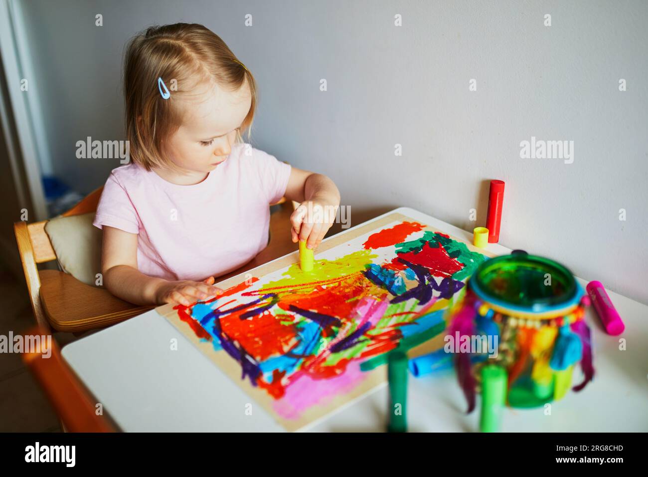 Adorable little girl drawing with colorful paints at home, in ...