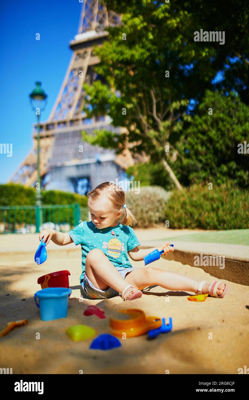 Adorable little girl having fun on playground in sandpit near the ...