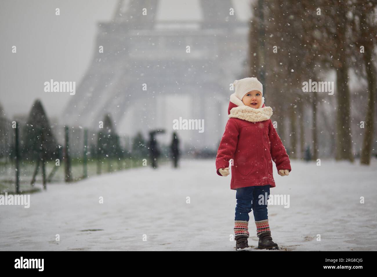 Adorable toddler girl near the Eiffel tower on a day with heavy ...