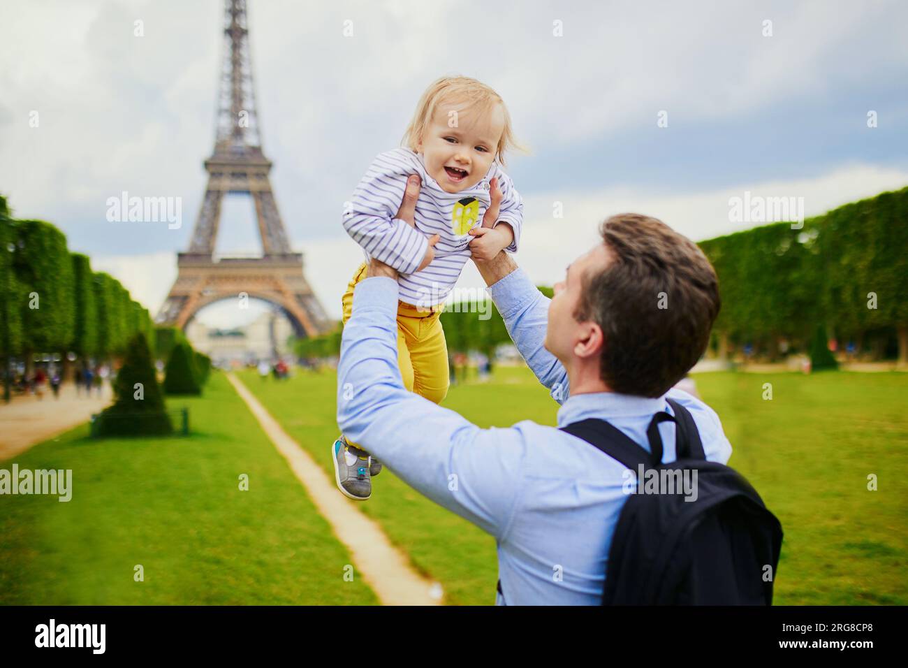 Father holding his adorable daughter in Paris near the Eiffel tower ...