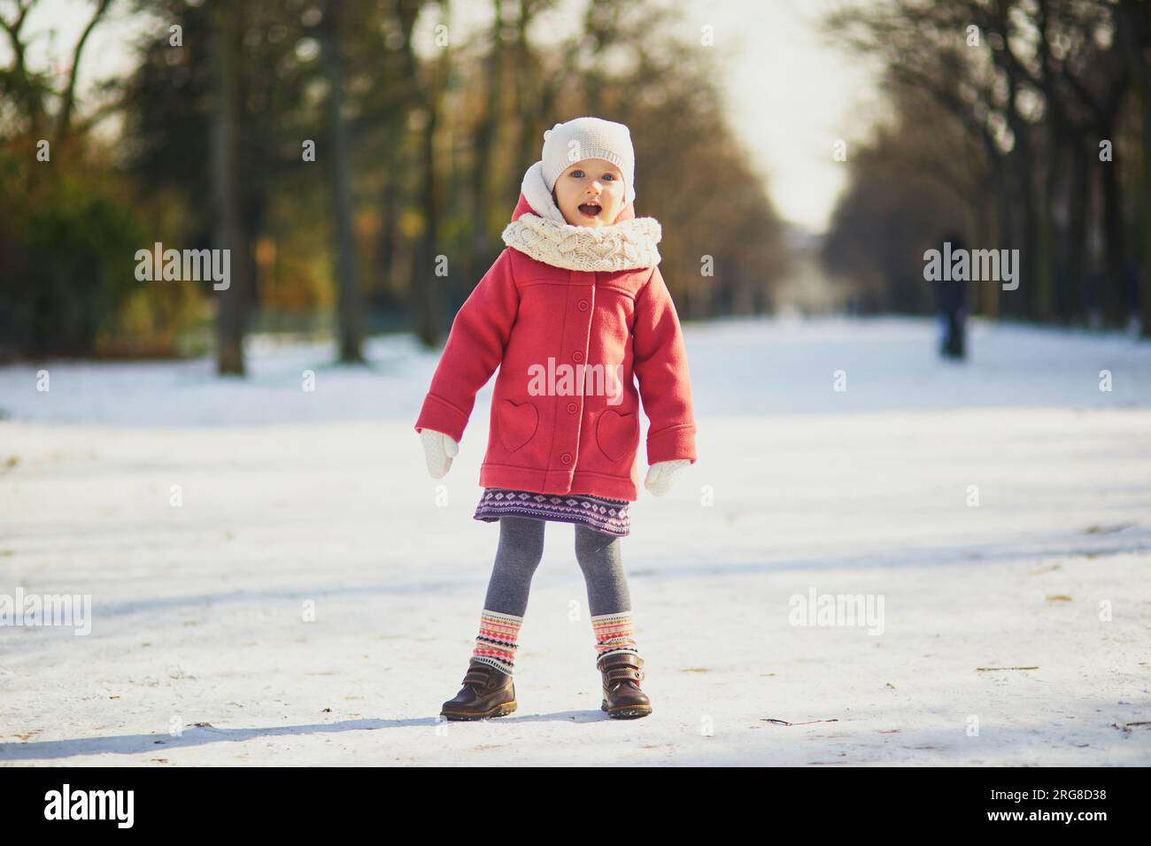 Adorable toddler girl on a sunny snow day. Happy child playing with ...