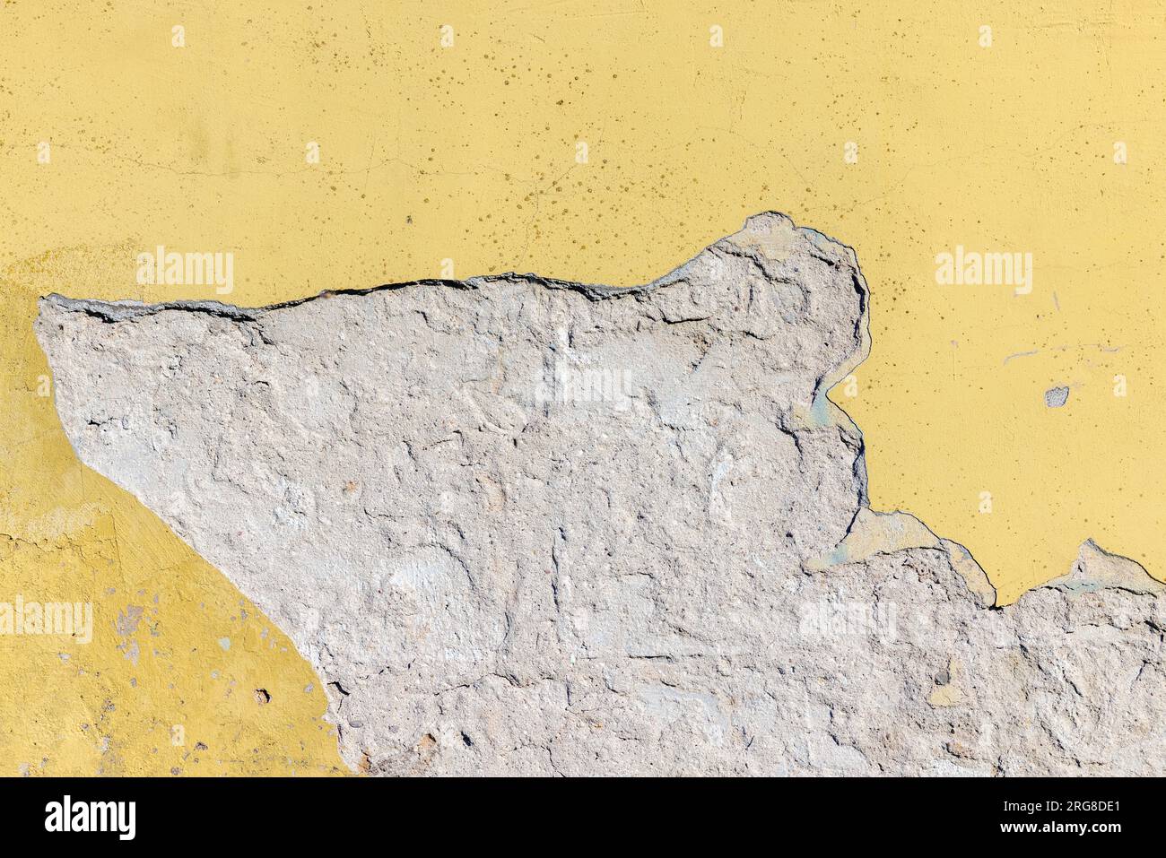 Damaged yellow plaster of a concrete wall, part of a damaged building ...