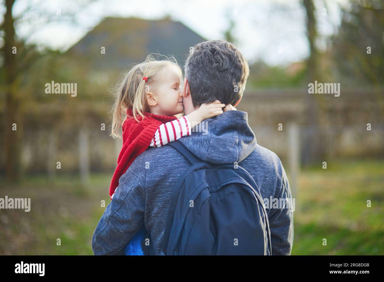 Man holding adorable toddler girl in his arms during a walk. Happy ...