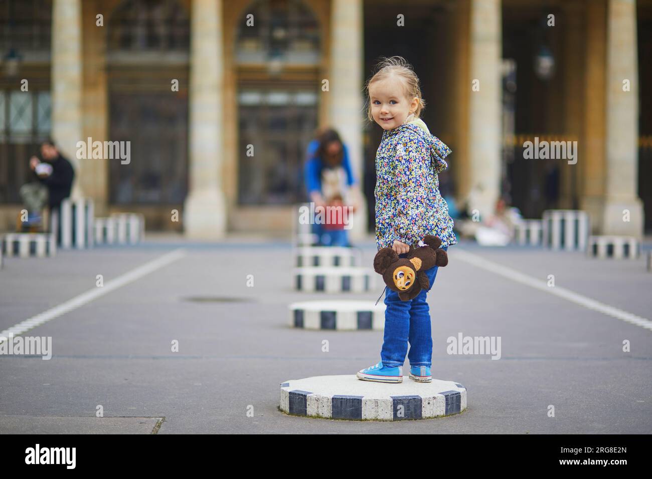Happy cheerful toddler girl running within Columns of Buren in Palais ...