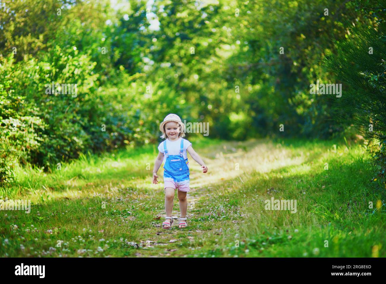 Adorable toddler girl having fun outdoors on a sunny summer day. Happy ...