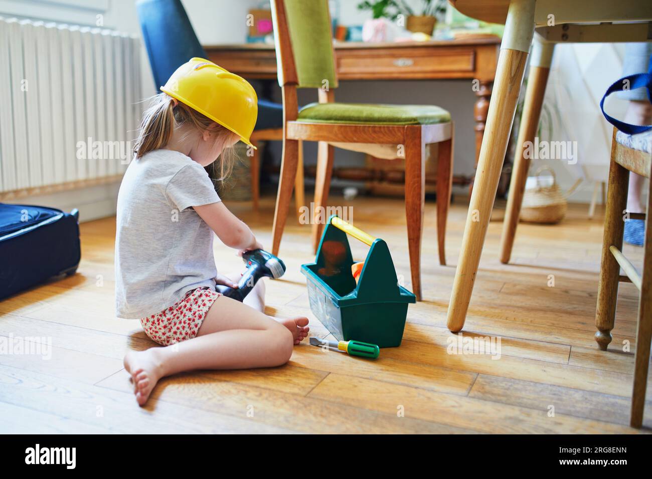 Adorable preschooler girl playing with repair tools at home. Indoors ...