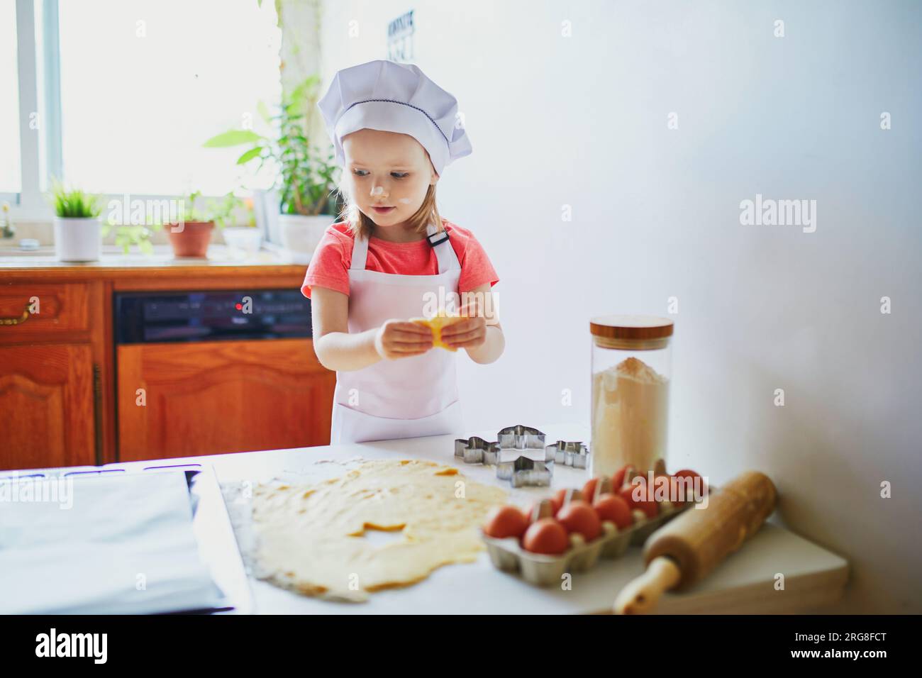 Adorable preschooler girl making cookies. Child helping to cook food in ...