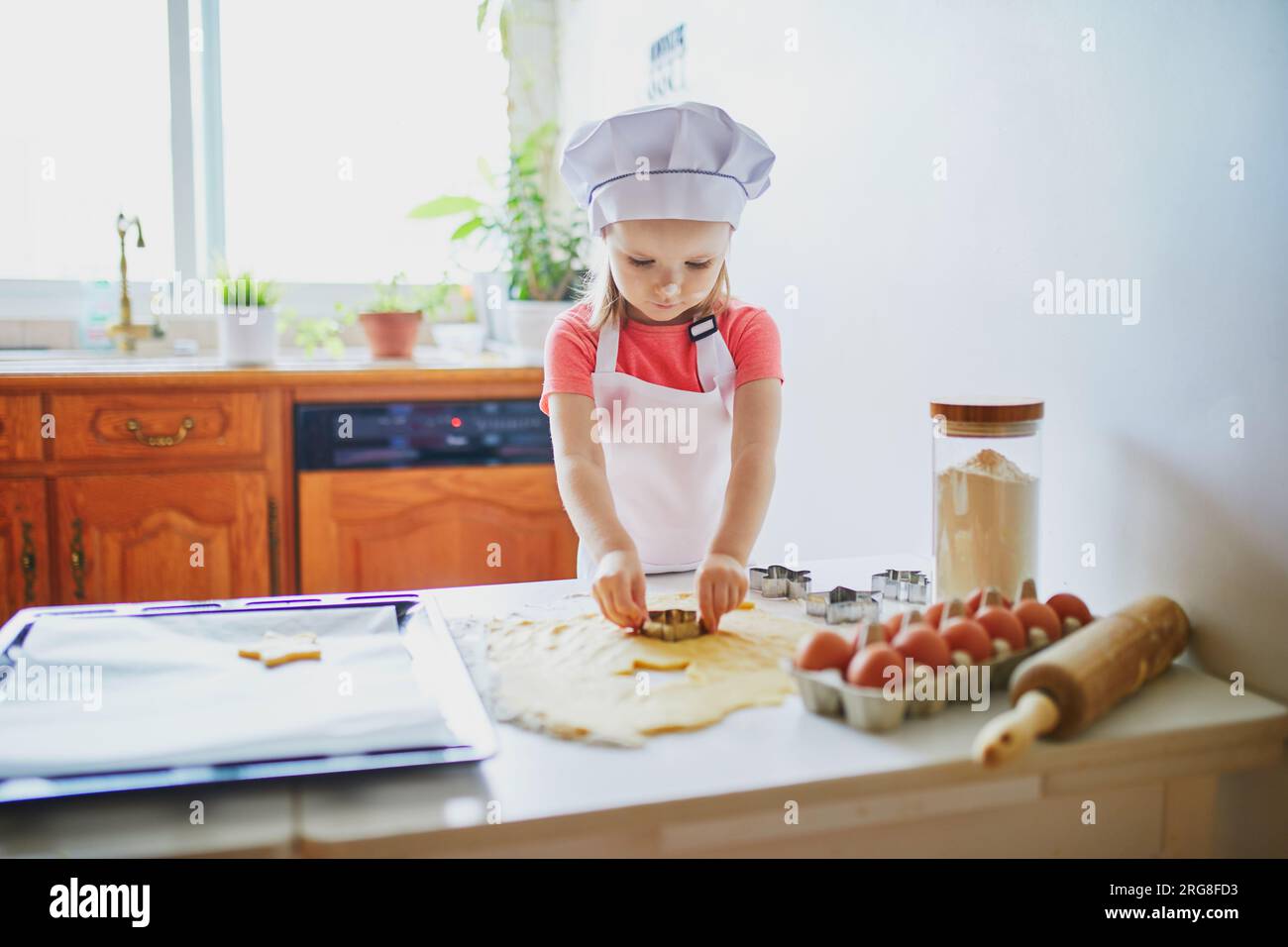 Adorable preschooler girl making cookies. Child helping to cook food in ...