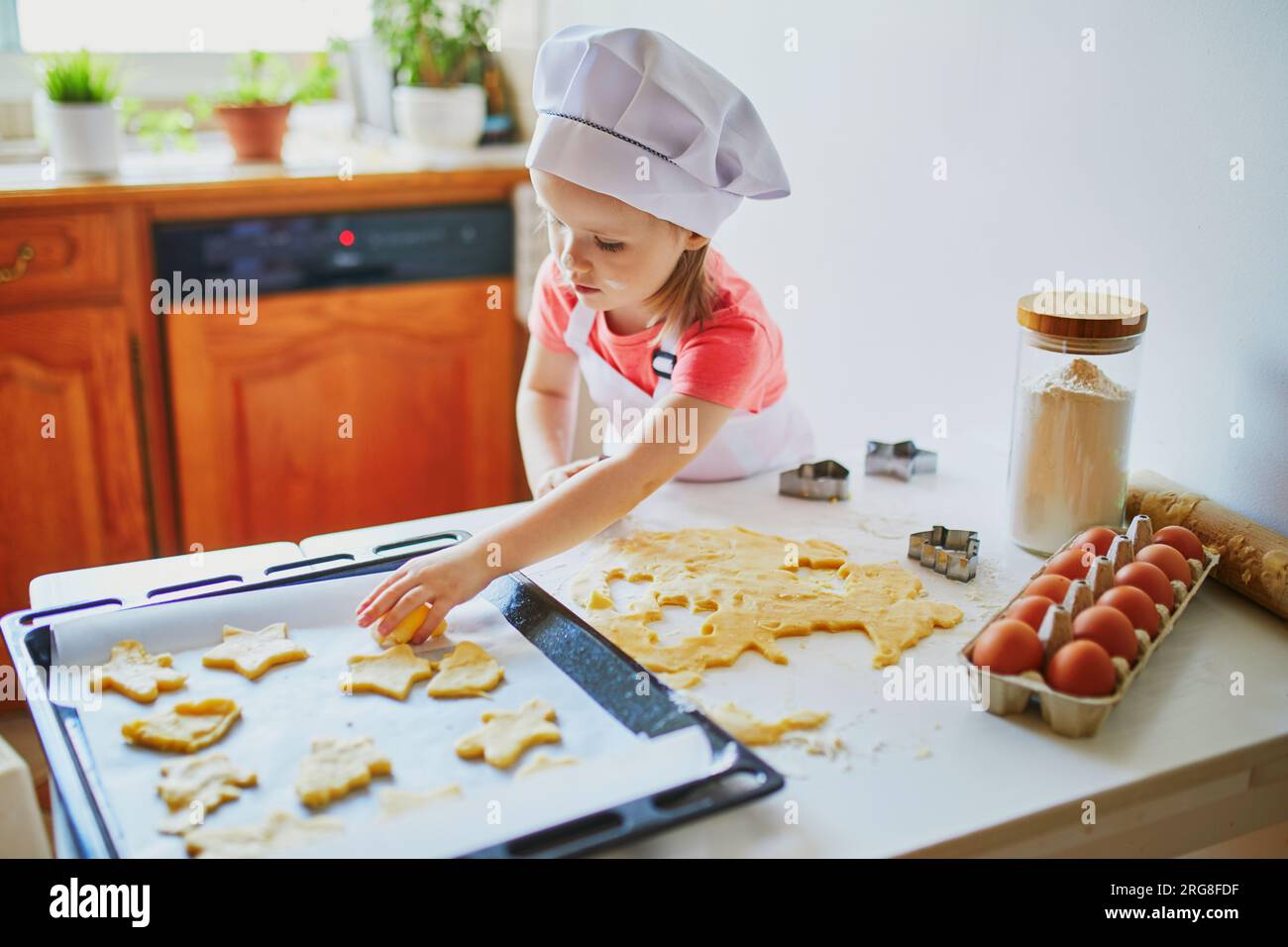 Adorable preschooler girl making cookies. Child helping to cook food in ...