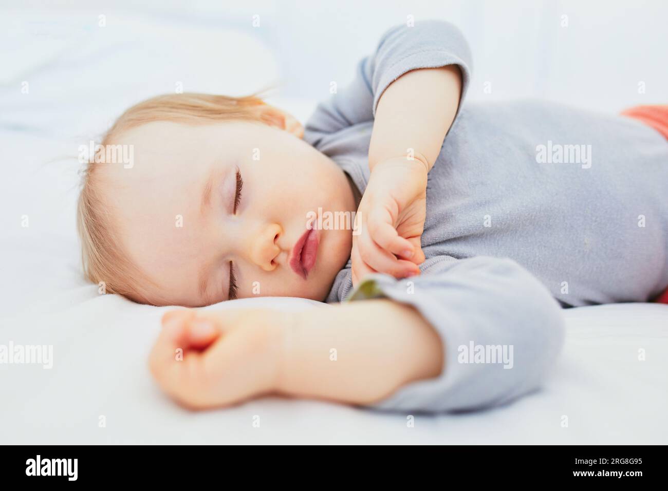 Adorable baby girl sleeping in crib. Small kid having day nap in parents bed Stock Photo - Alamy