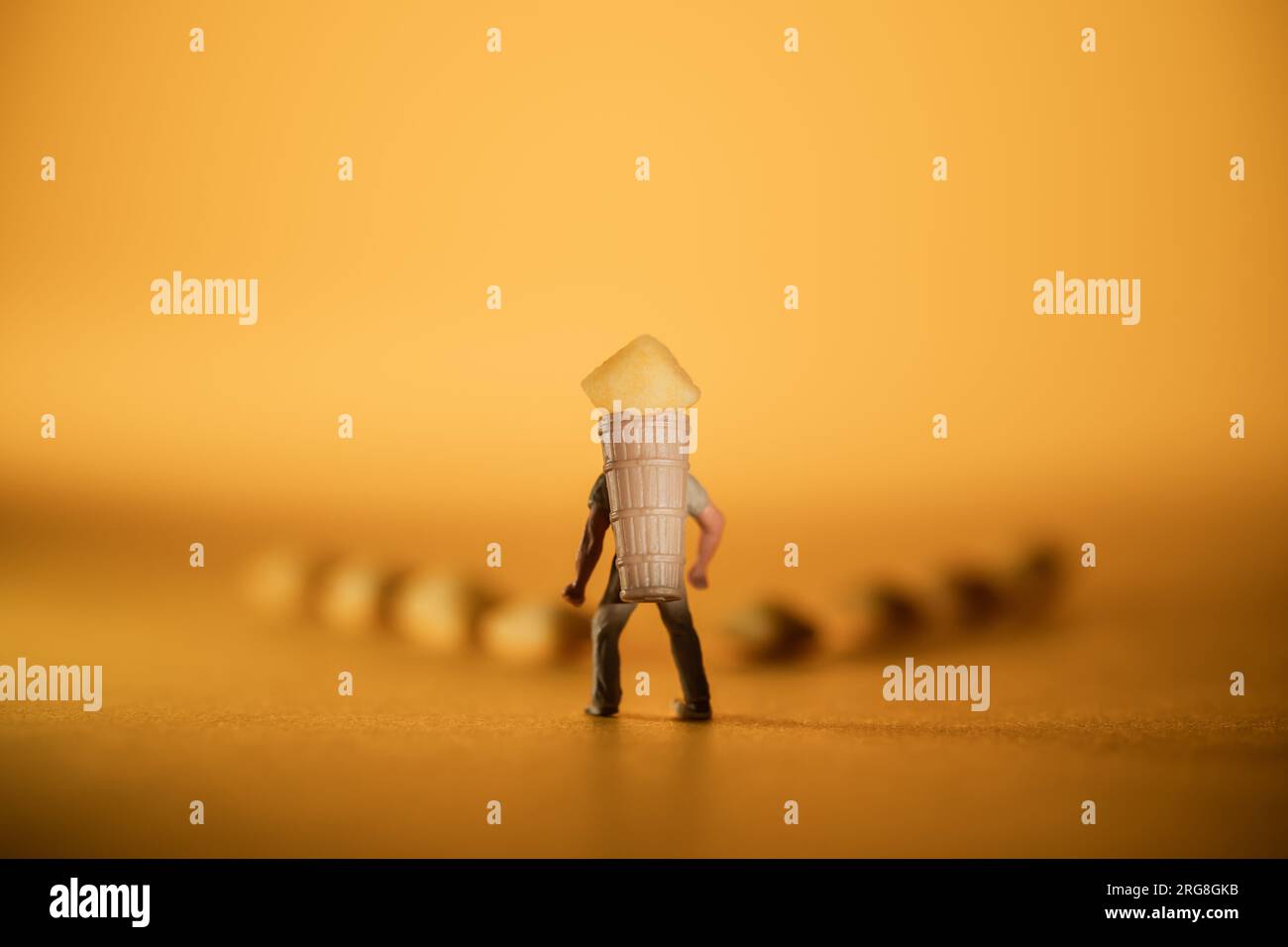 Miniature Asian manual construction workers are clearing rocks from a ...