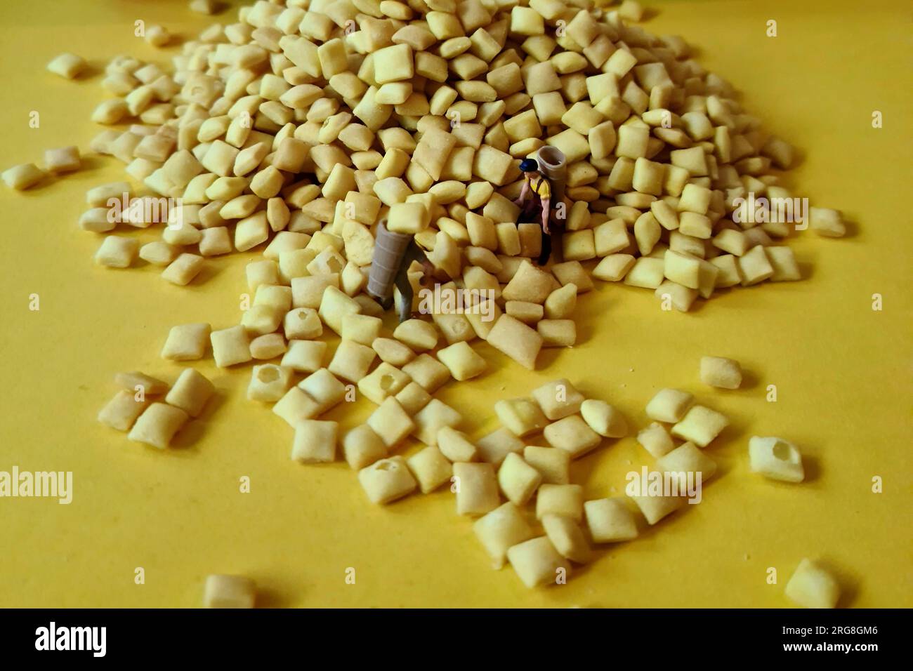 Miniature Asian manual construction workers are clearing rocks from a ...
