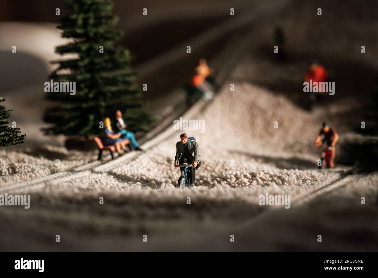 park and leisure concept Miniature cyclist is cycling down a slope ...