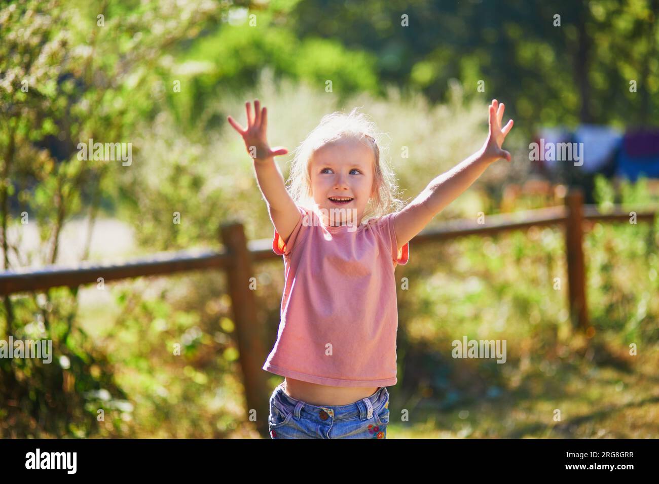 Happy cheerful preschool girl walking in park. Outdoors summer ...