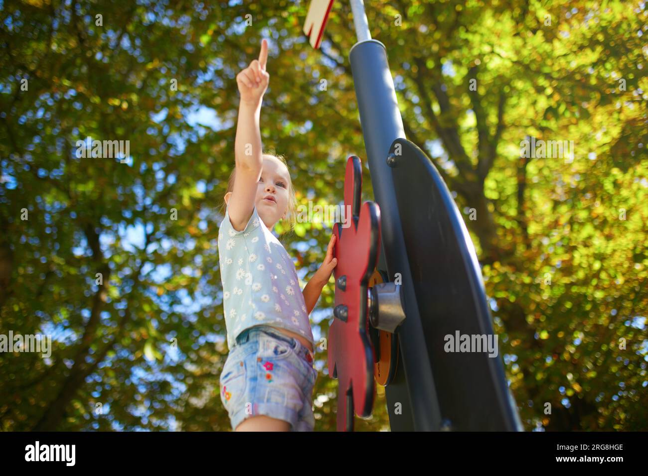 Adorable little girl on playground on a sunny day. Preschooler child ...