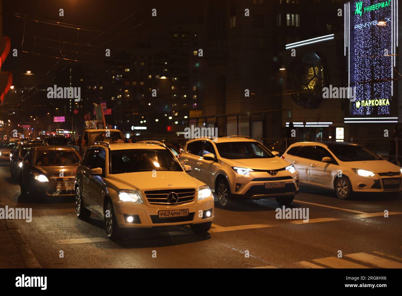 Nightview of cars on a busy street in the city; western car Mercedes in ...