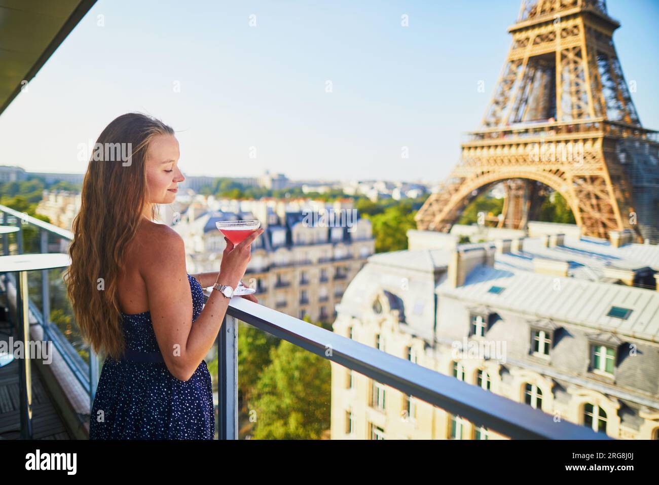Beautiful young woman drinking alcoholic cocktail in a rooftop ...