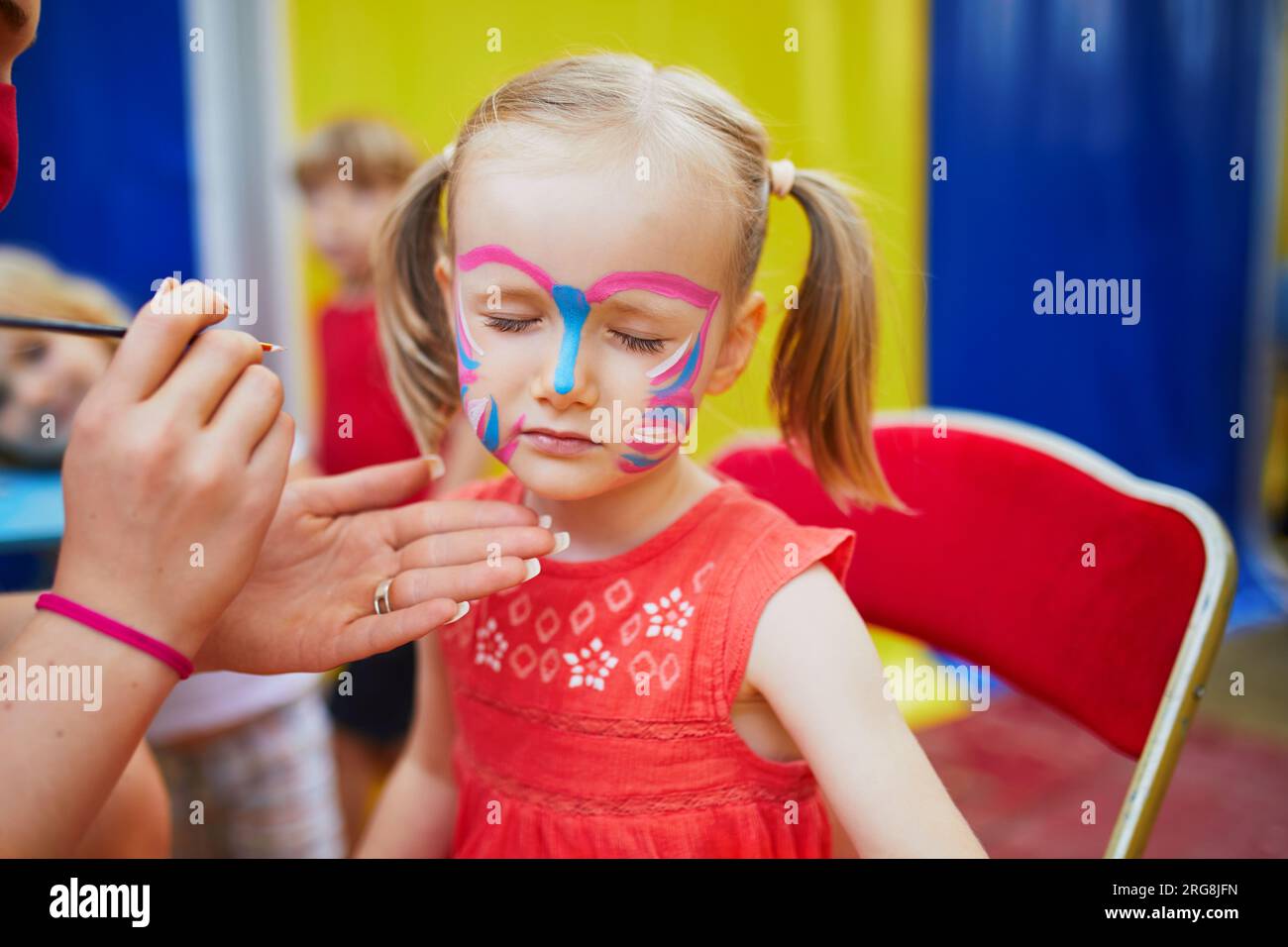 Children face painting. Artist painting little preschooler girl like ...