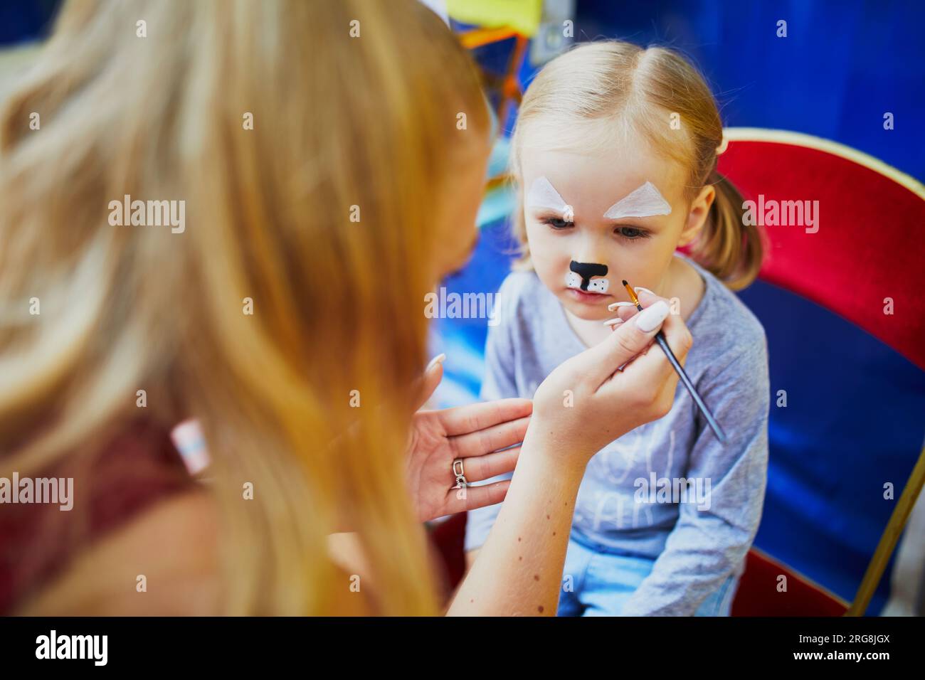 Children face painting. Artist painting little preschooler girl like ...