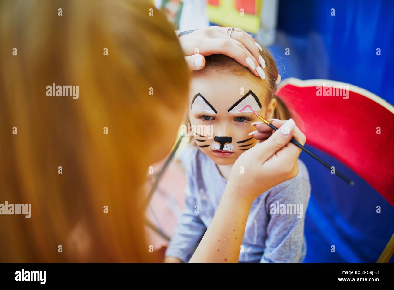 Children face painting. Artist painting little preschooler girl like ...