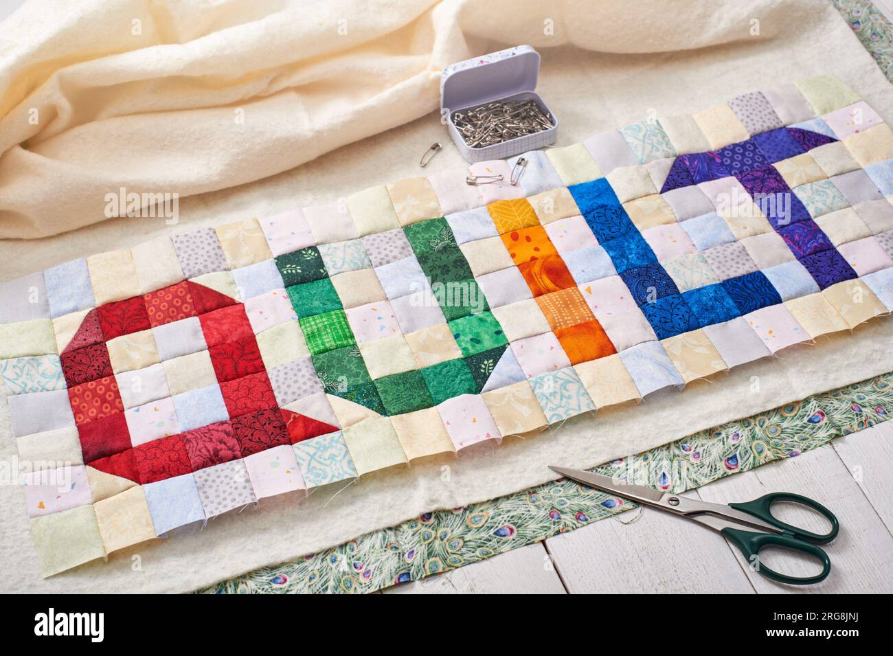 The word quilt sewn from colorful square and triangle pieces of fabric ...