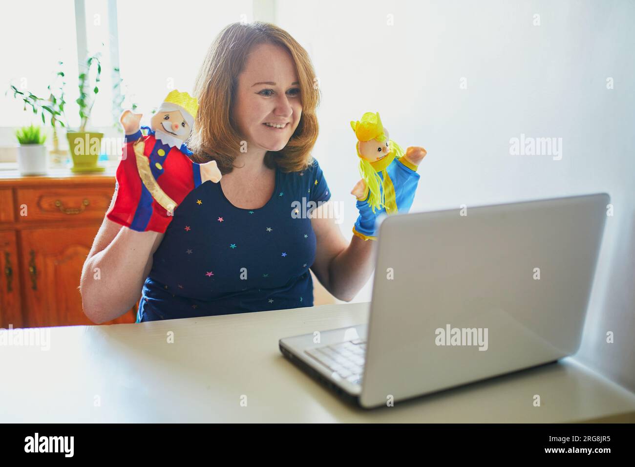 Kindergarten teacher in front of laptop having video conference chat ...
