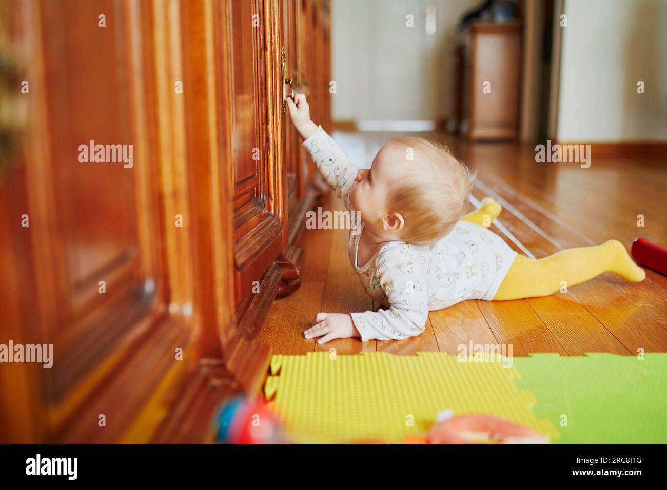 Baby girl learning to crawl. Happy healthy little child on the floor ...