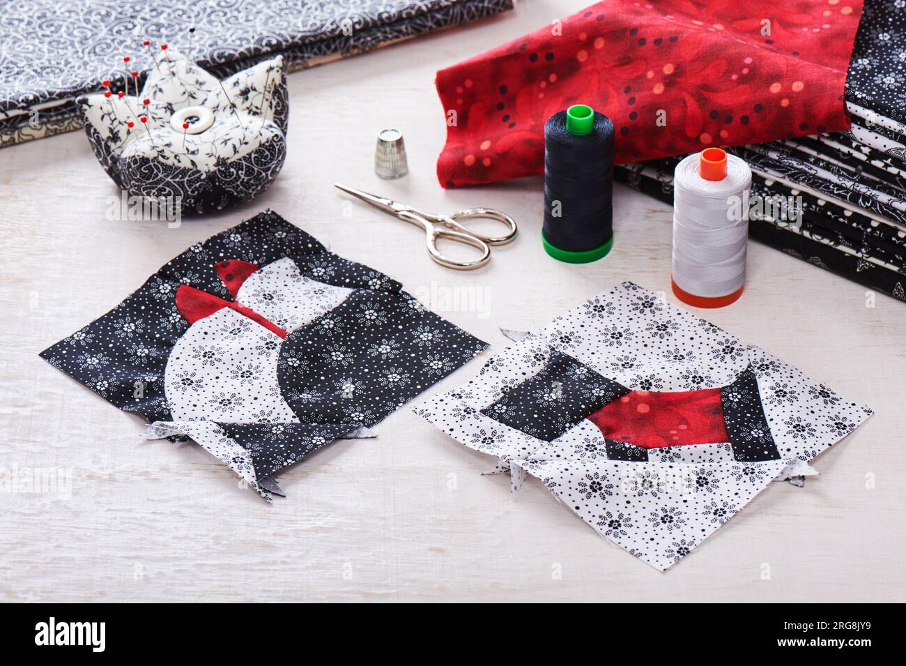 Sewing patchwork of blocks white cat and black dog, sewing accessories ...