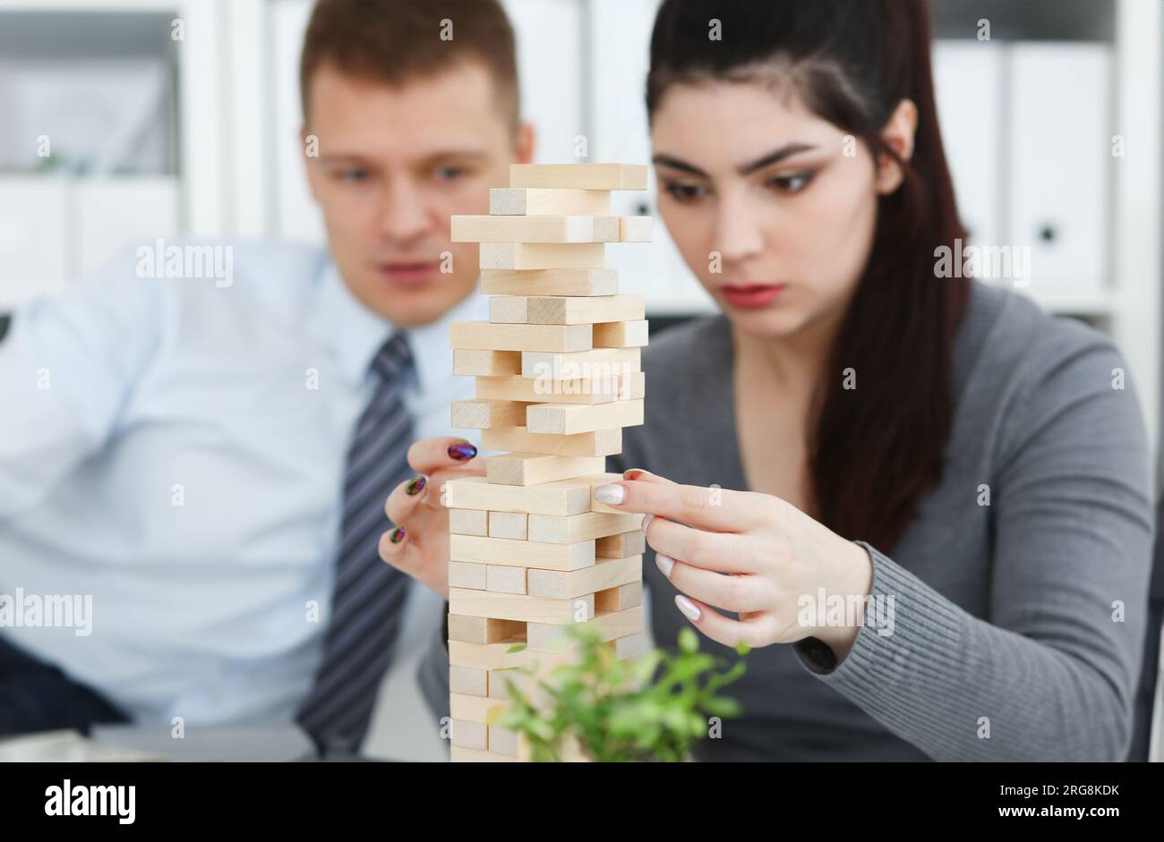 Businessman plays in a strategy of jenga hand Stock Photo - Alamy