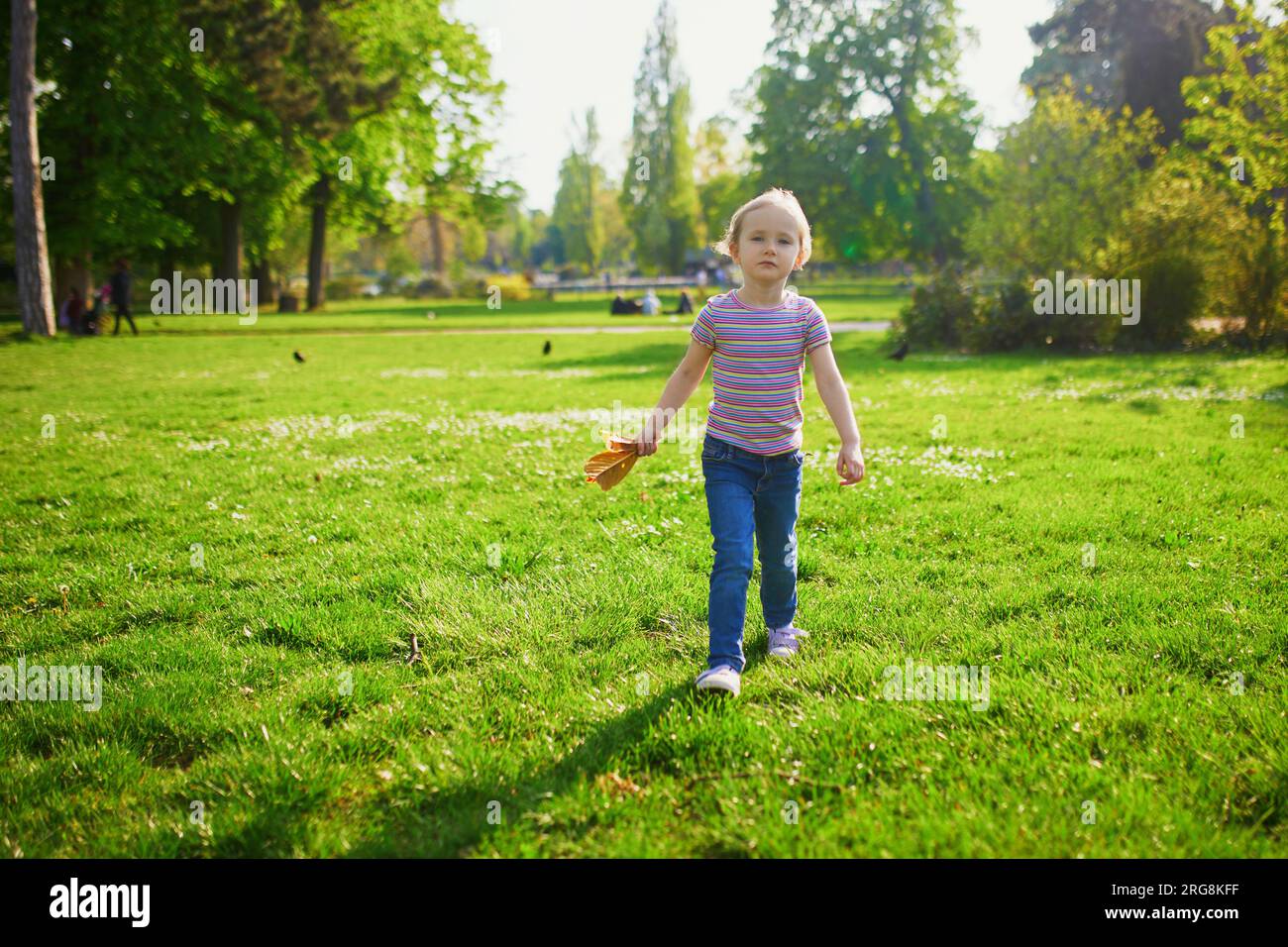 Unhappy preschooler girl in park. Moody kid walking outdoors Stock ...