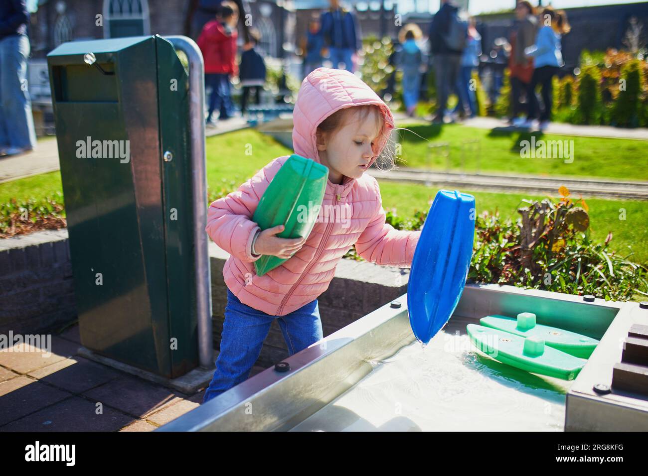 Little girl playing with toy water dam experimenting with balance wan ...