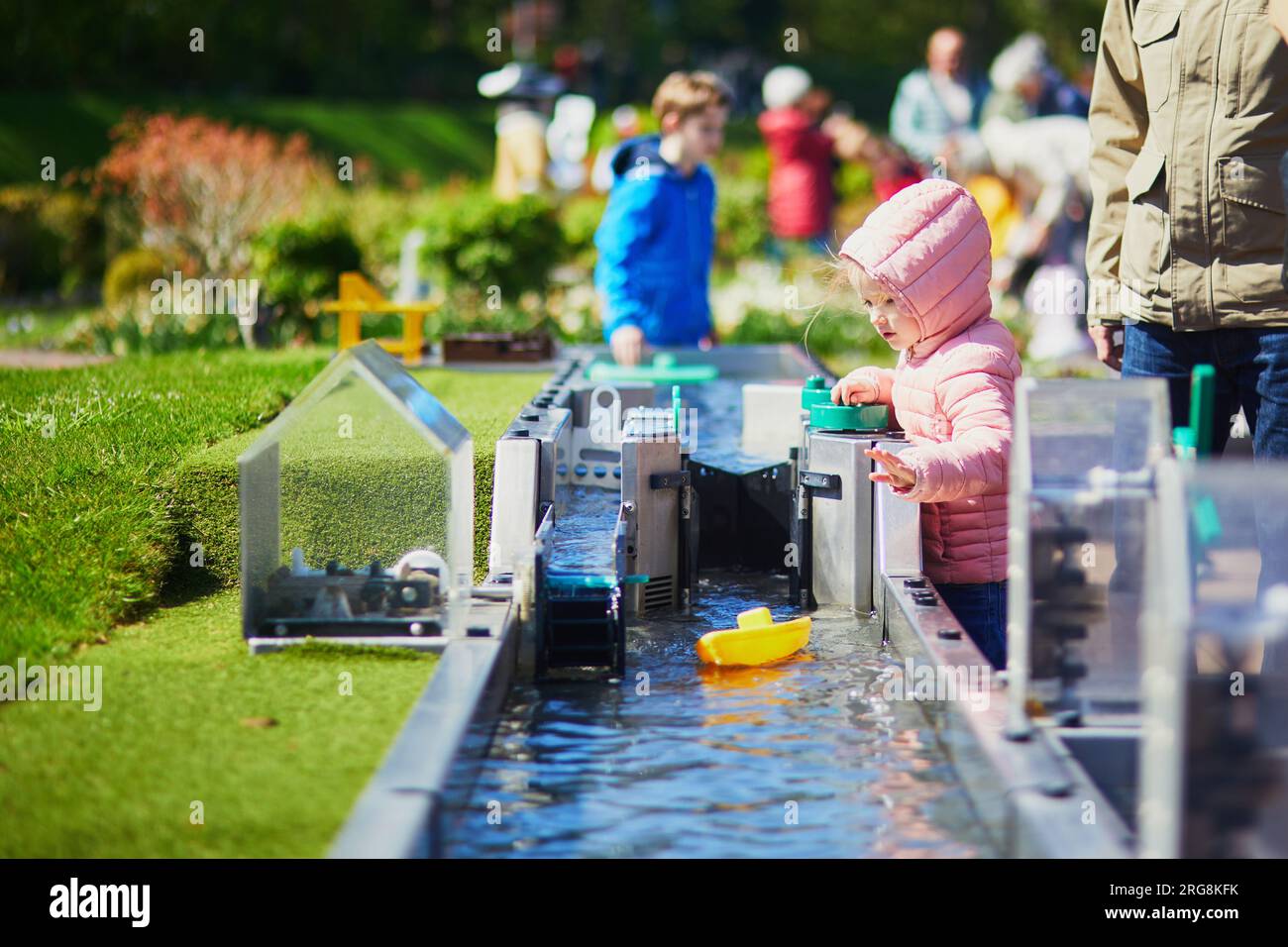 Little girl playing with toy water dam experimenting with balance wan ...