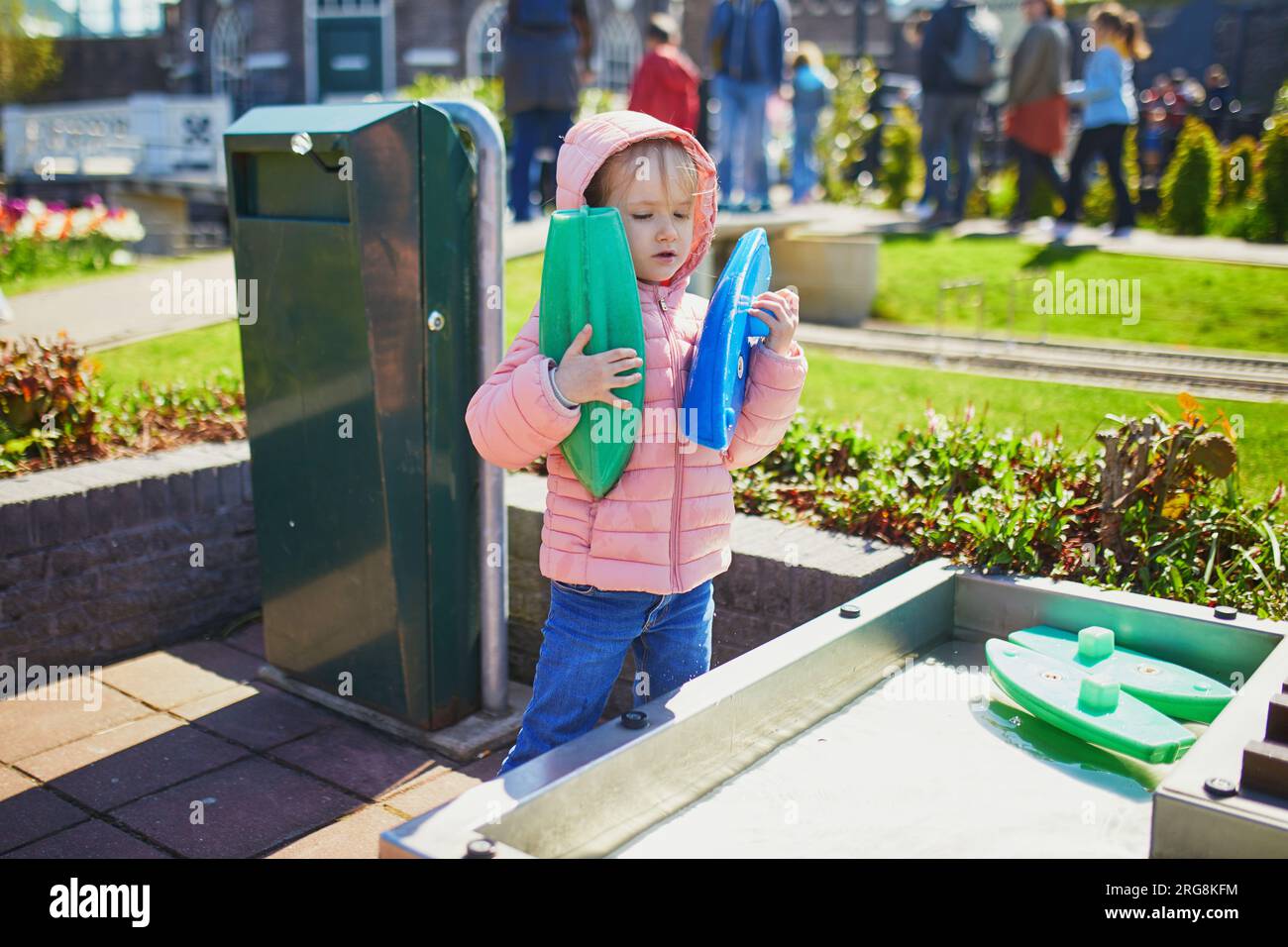 Little girl playing with toy water dam experimenting with balance wan ...