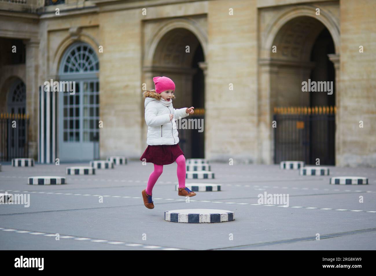 Adorable preschooler girl playing in Palais Royal garden. Child having ...