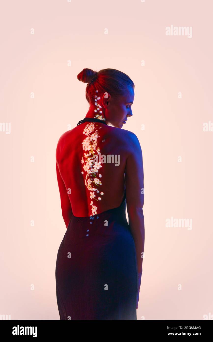 Back view. Studio shoot of beautiful woman's back in digital neon ...
