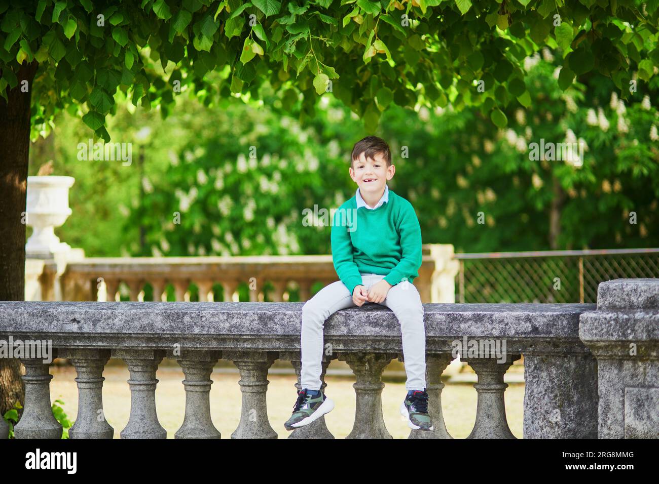 Eight Year Old Boy With Chestnuts In Bloom In Tuileries Garden In Paris eight-year-old-boy-with-chestnuts-in-bloom-in-tuileries-garden-in-paris