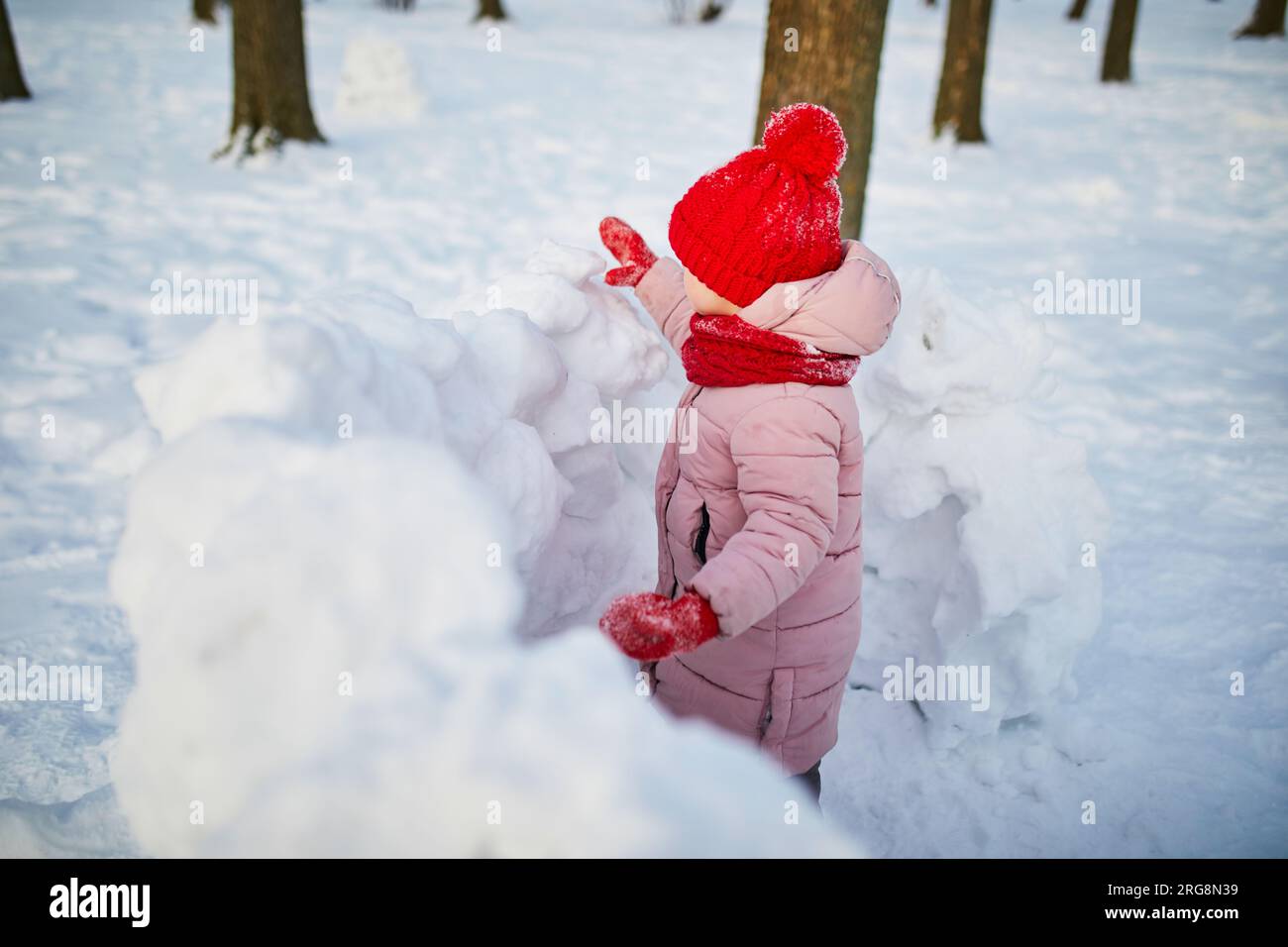 Adorable preschooler girl having fun in beautiful winter park on a ...