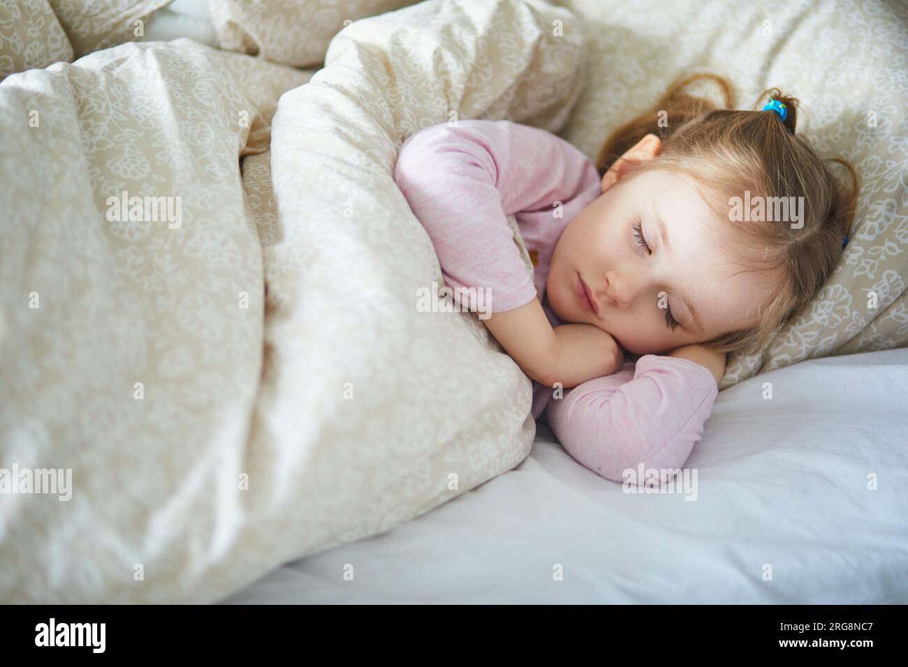 Adorable preschooler girl having a day nap. Little child sleeping in ...