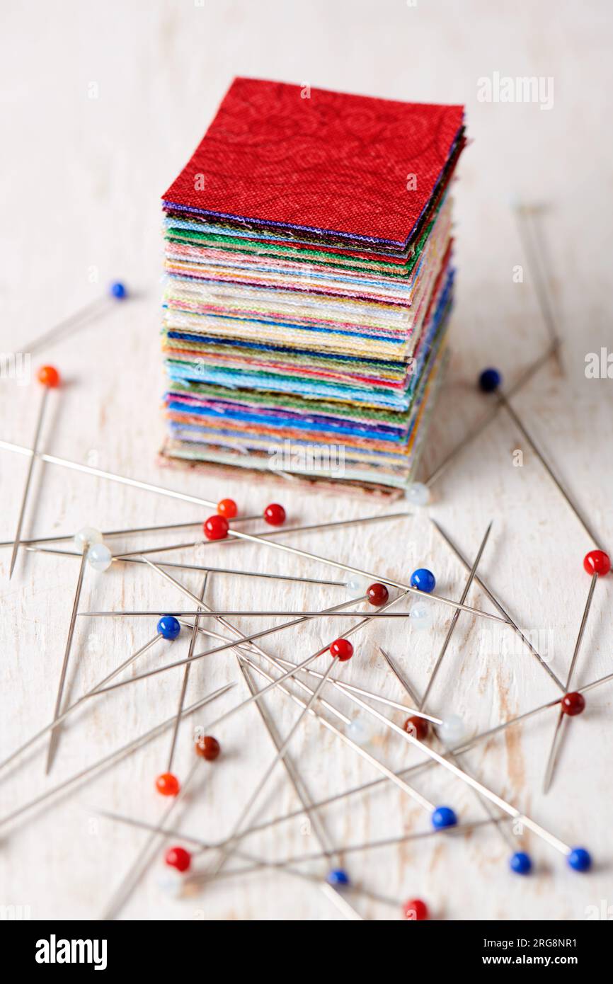 Stack of square pieces of colorful fabrics and heap of multicolor ball ...