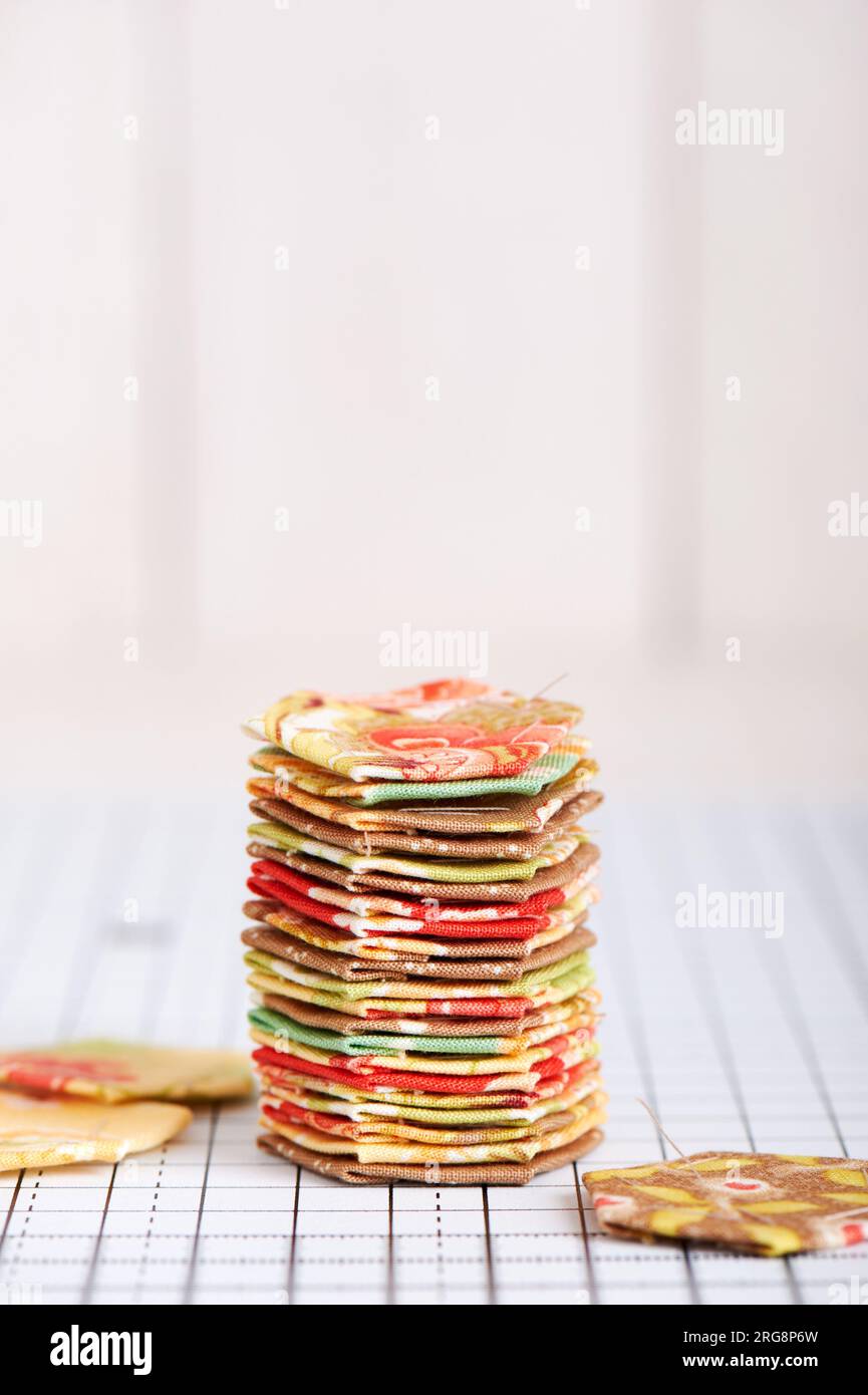Stack english paper pieced hexagons on white craft mat Stock Photo - Alamy