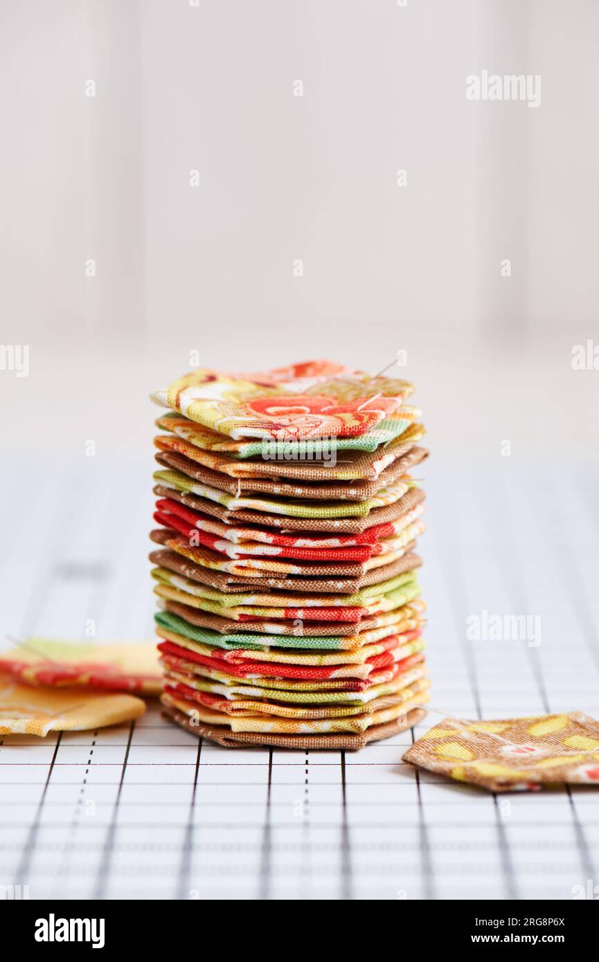 Stack english paper pieced hexagons on white craft mat Stock Photo - Alamy