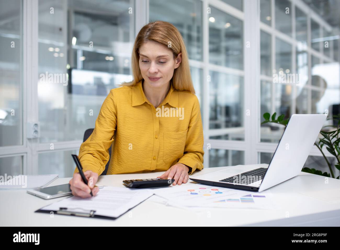 Serious thinking business woman behind paper work, woman boss ...